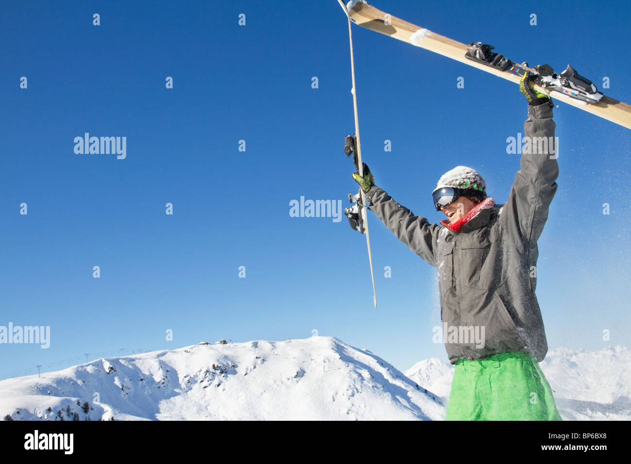 Young man holding his skis above his head Stock Photo - Alamy