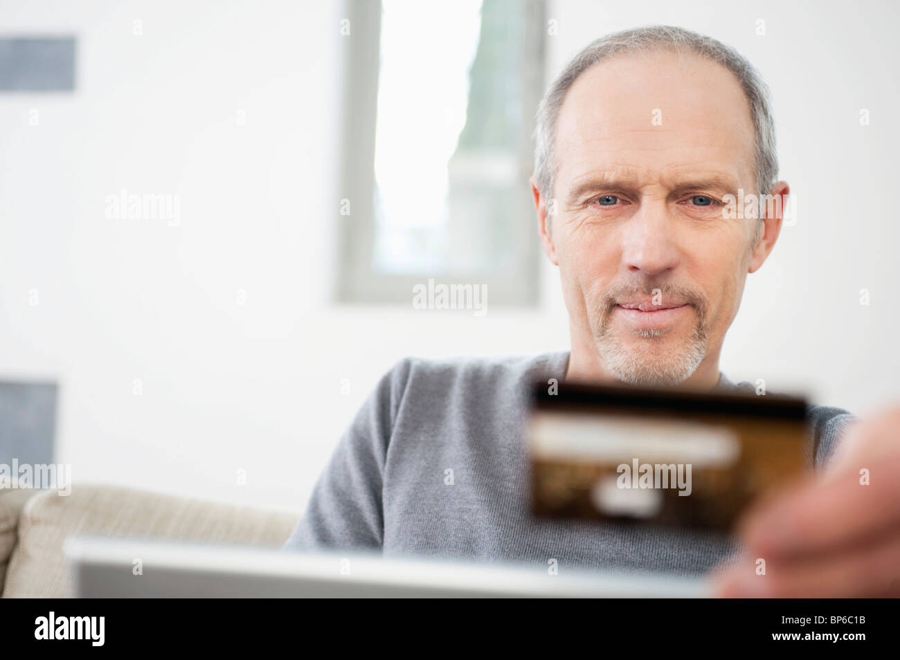 Man doing online shopping with a laptop Stock Photo - Alamy