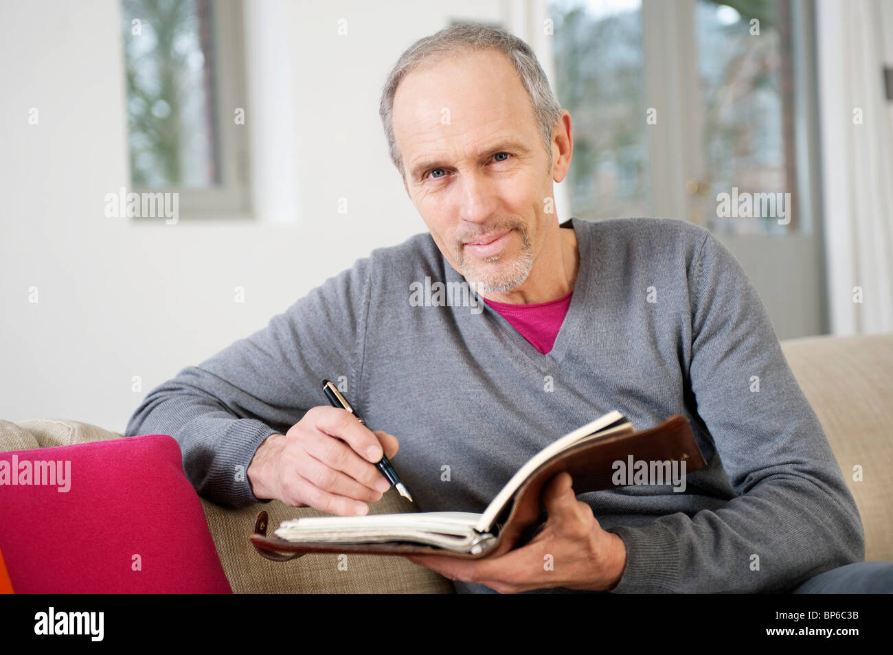 Man writing in a personal organizer Stock Photo - Alamy
