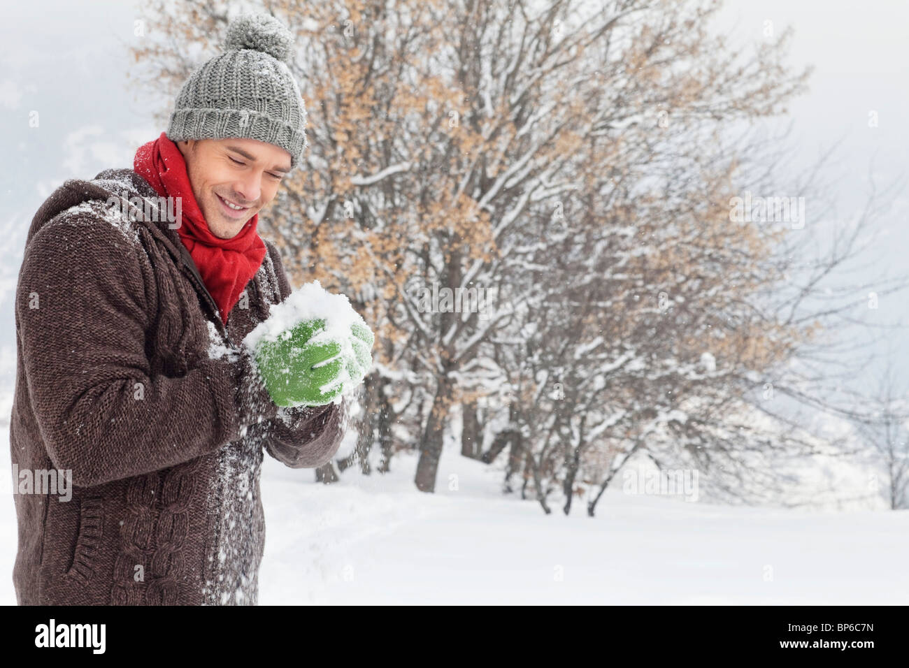 Young man making a snowball Stock Photo - Alamy