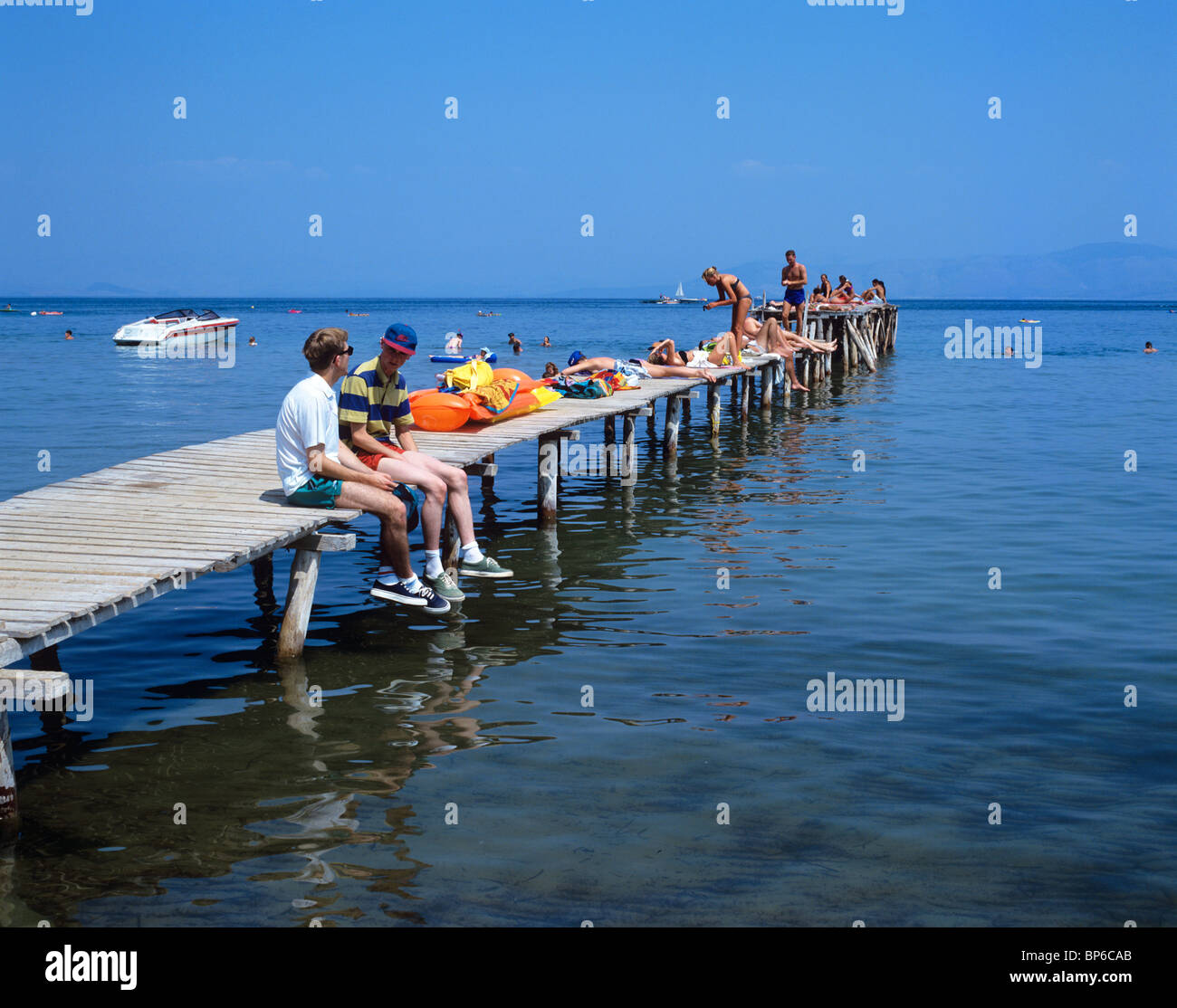 Sunbathers on a boat jetty at the popular resort of Kavos near the ...