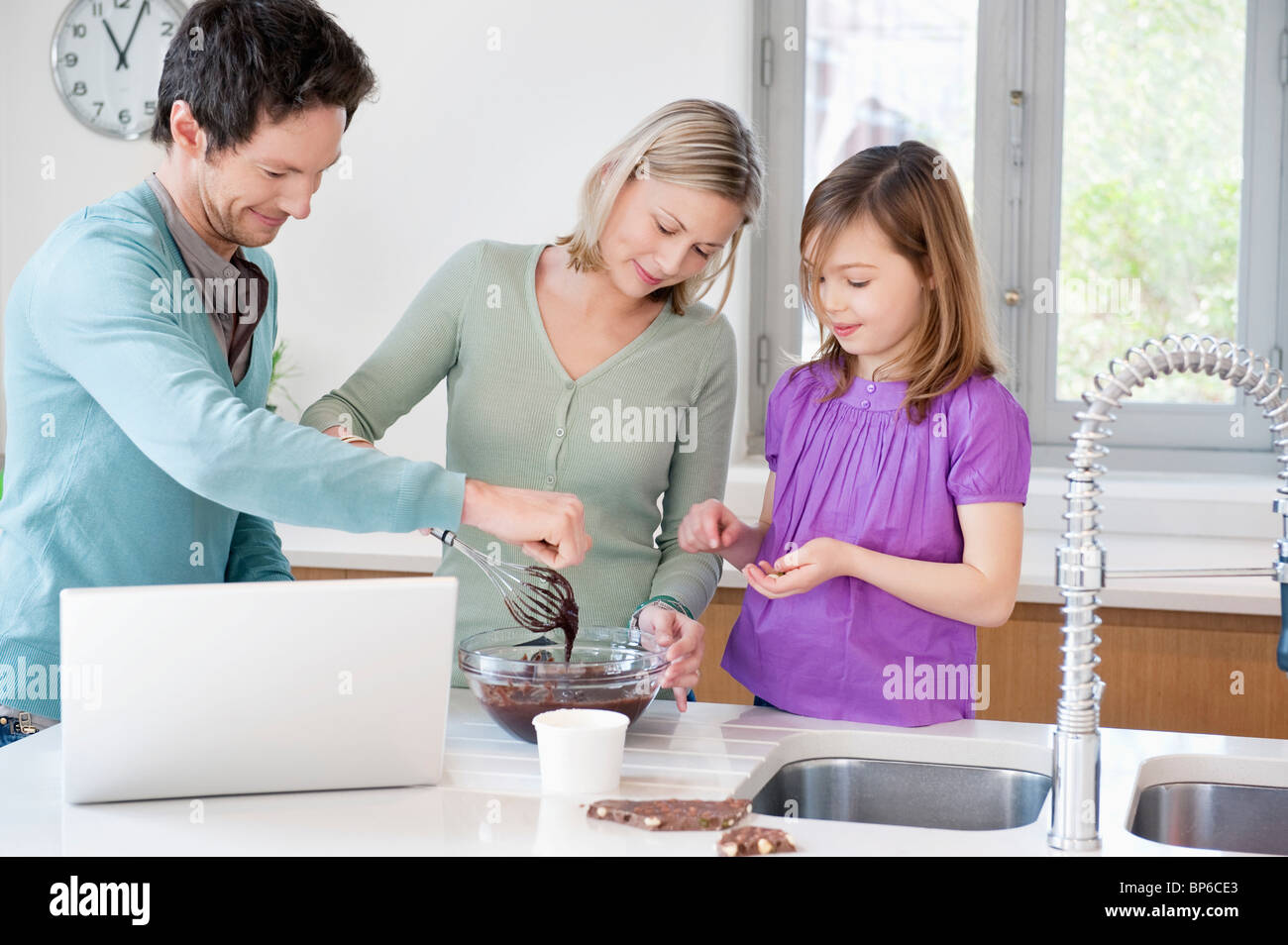 Family cooking with the recipe on a laptop Stock Photo - Alamy