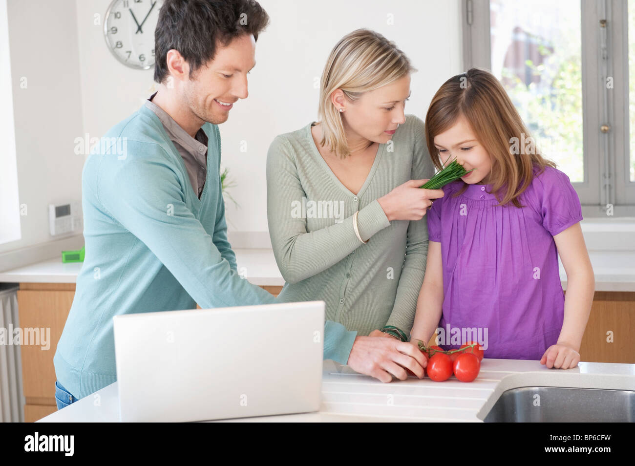 Family cooking with the recipe on a laptop Stock Photo - Alamy