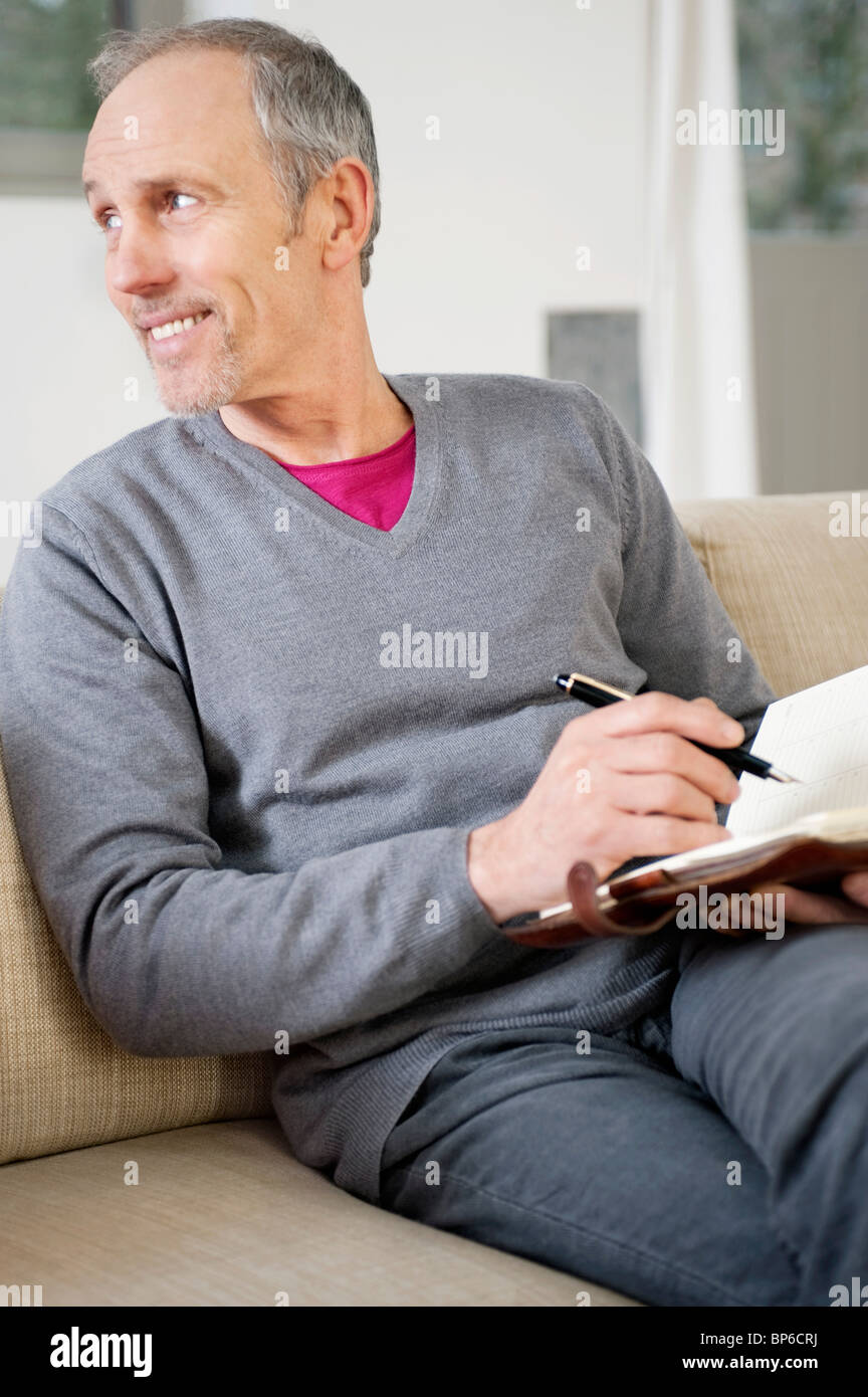 Man writing in a personal organizer Stock Photo - Alamy