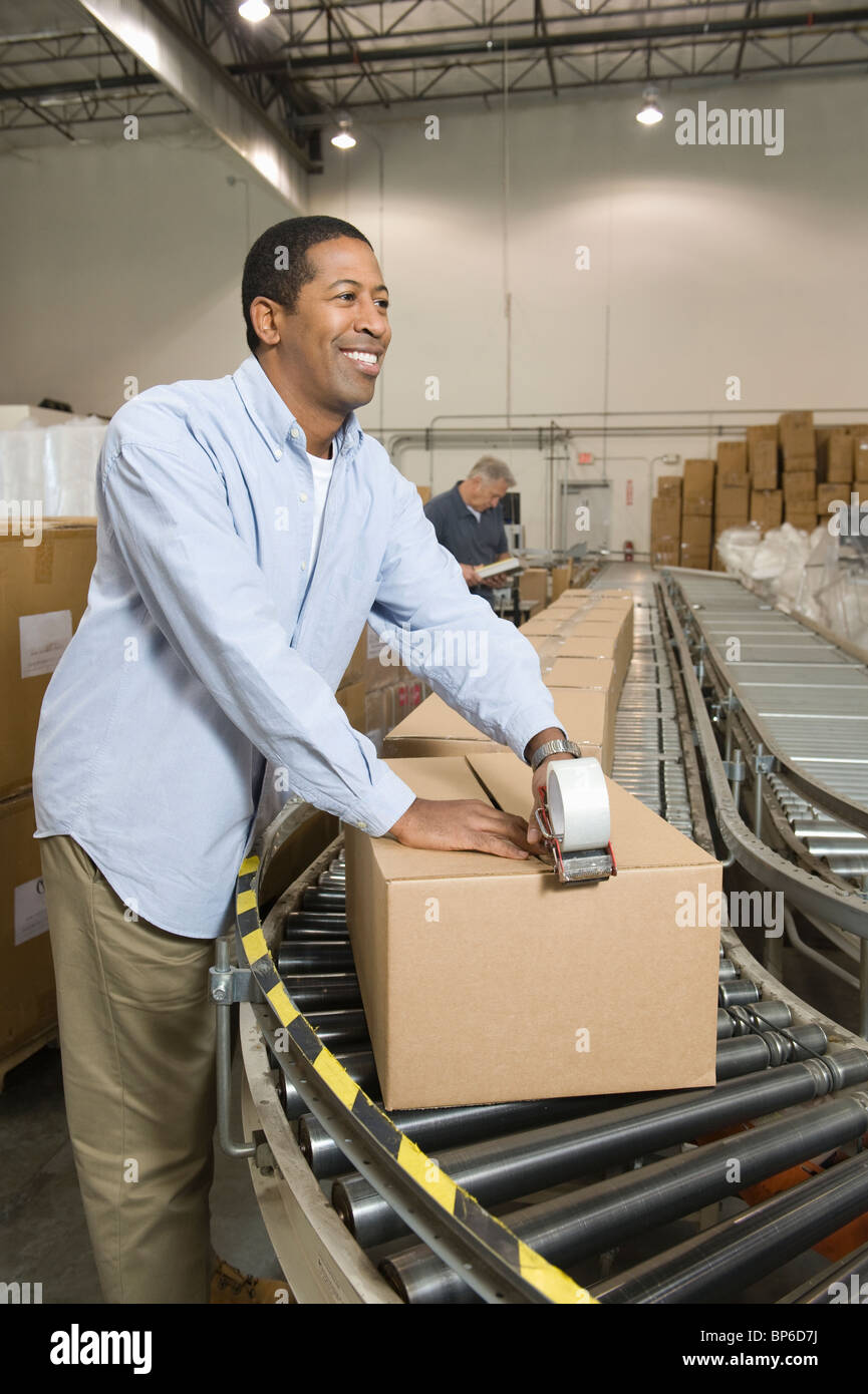 Cheerful man working in distribution warehouse Stock Photo - Alamy