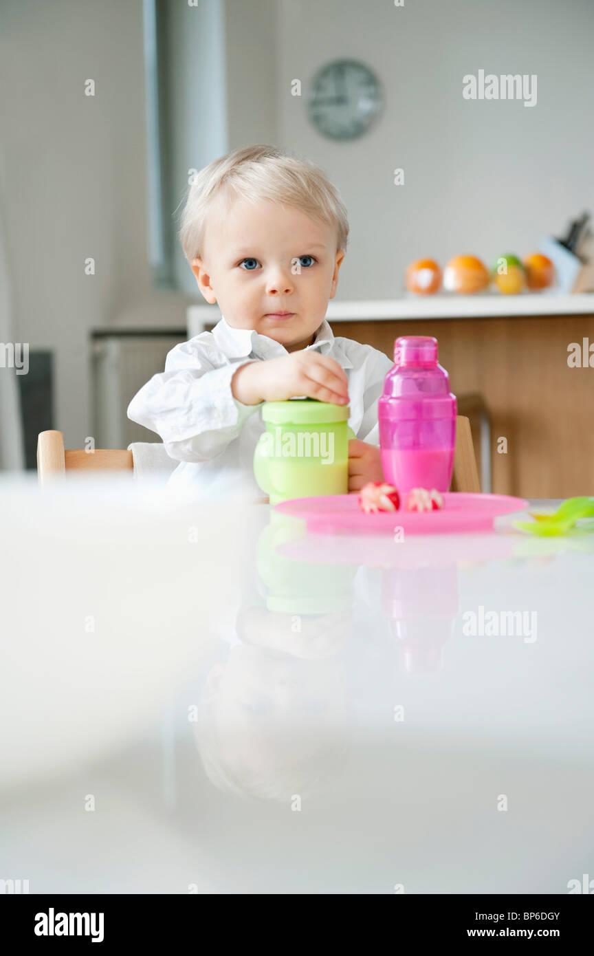 Boy sitting at a dining table Stock Photo - Alamy