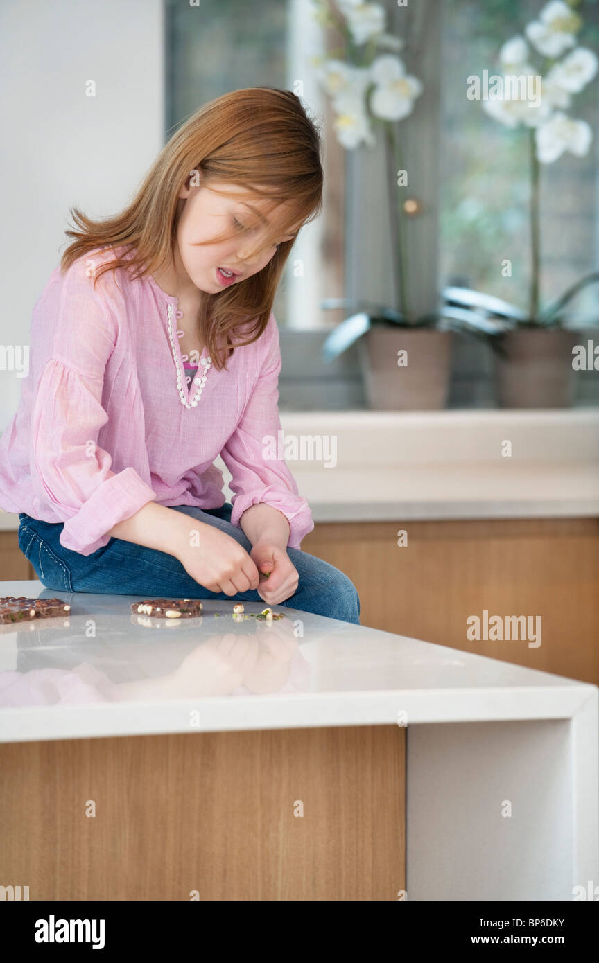 Girl sitting on a kitchen counter Stock Photo - Alamy