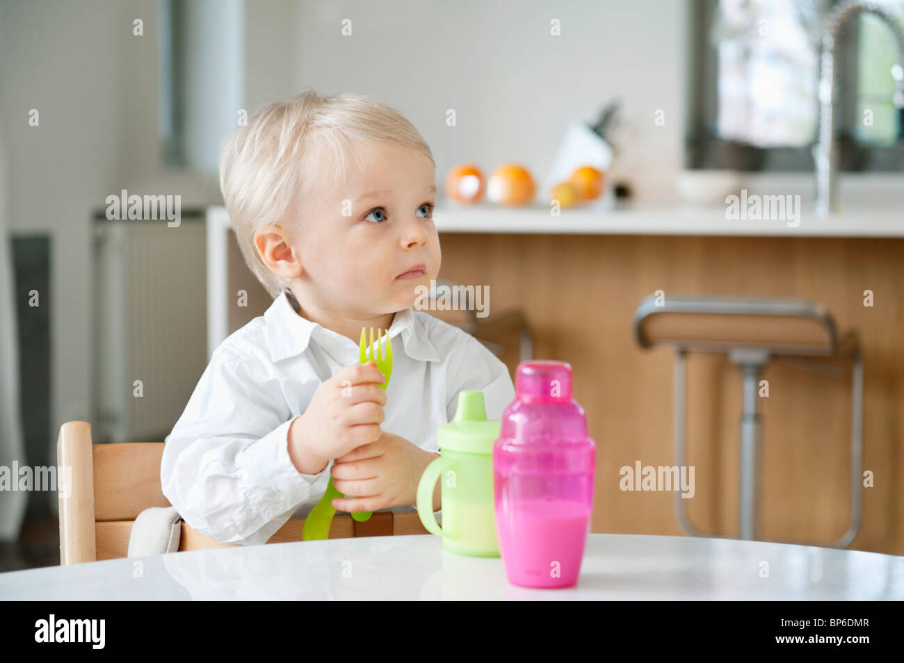 Boy sitting at a dining table Stock Photo - Alamy
