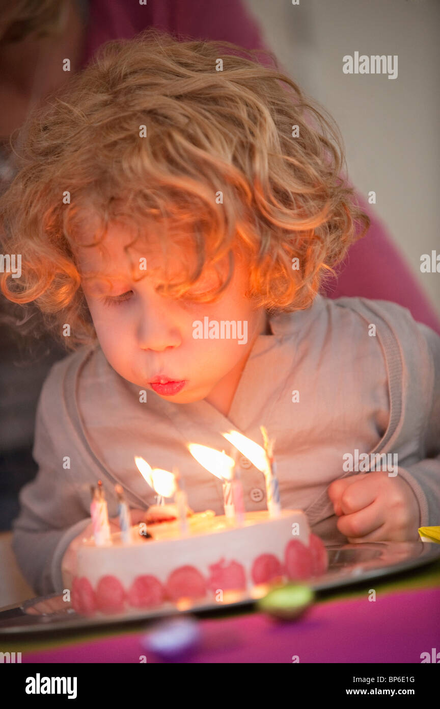Boy blowing out candles on his birthday cake Stock Photo - Alamy