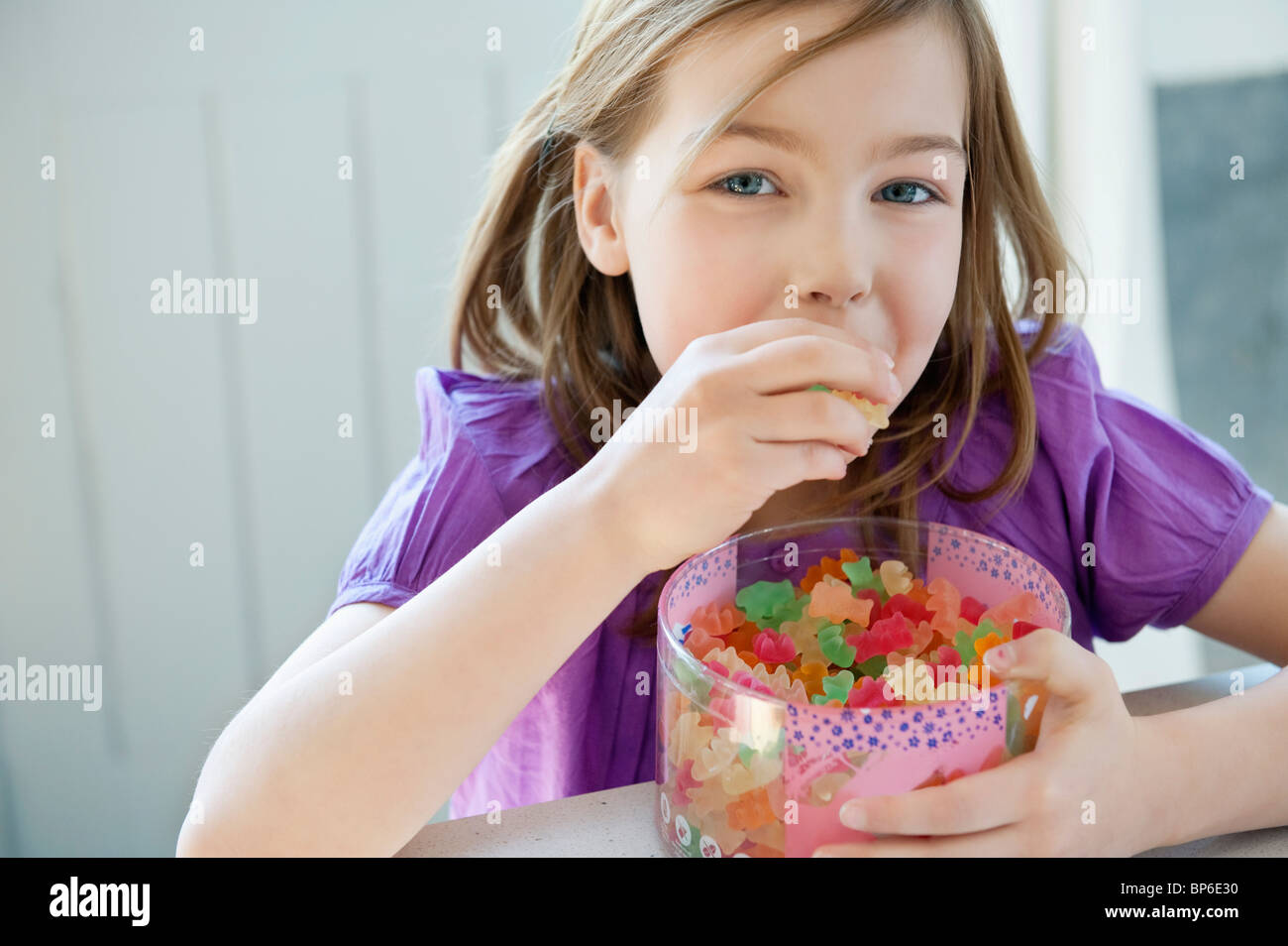 Portrait of a girl eating gum drops Stock Photo - Alamy