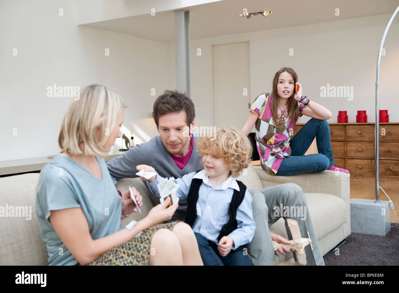 Family in a living room Stock Photo - Alamy