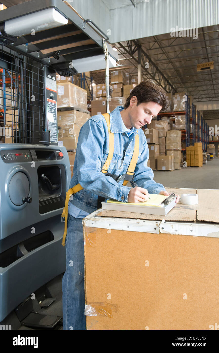 Man making notes in distribution warehouse Stock Photo - Alamy