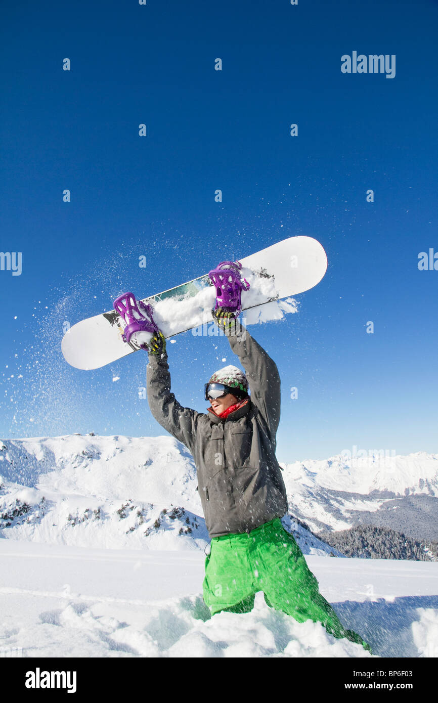 Young man holding his snowboard above his head Stock Photo - Alamy