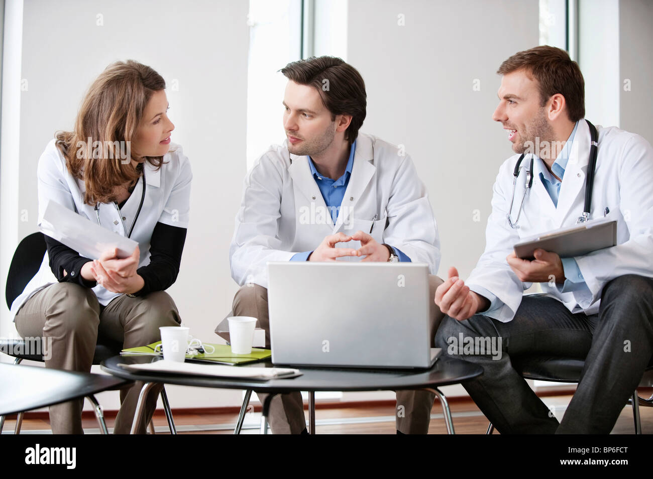 Three doctors talking to each other Stock Photo - Alamy