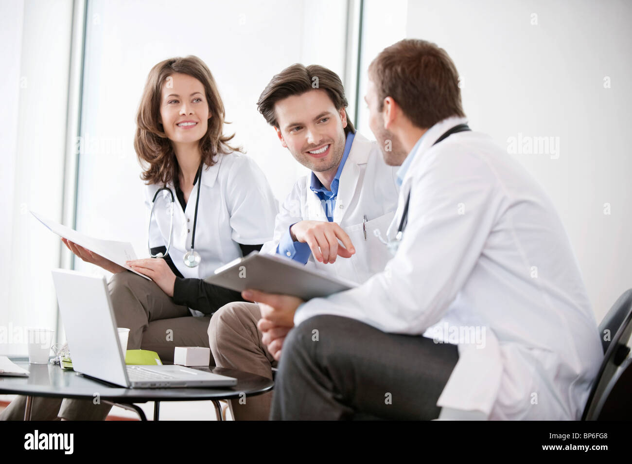 Three doctors talking to each other Stock Photo - Alamy