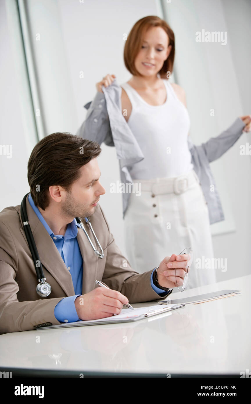 Woman getting dressed after treatment Stock Photo - Alamy