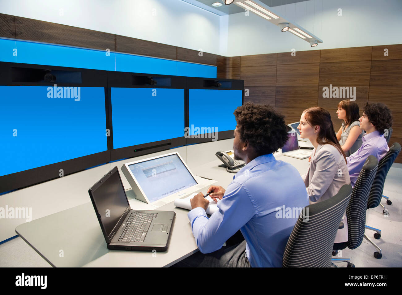 Business executives working in a control room Stock Photo - Alamy
