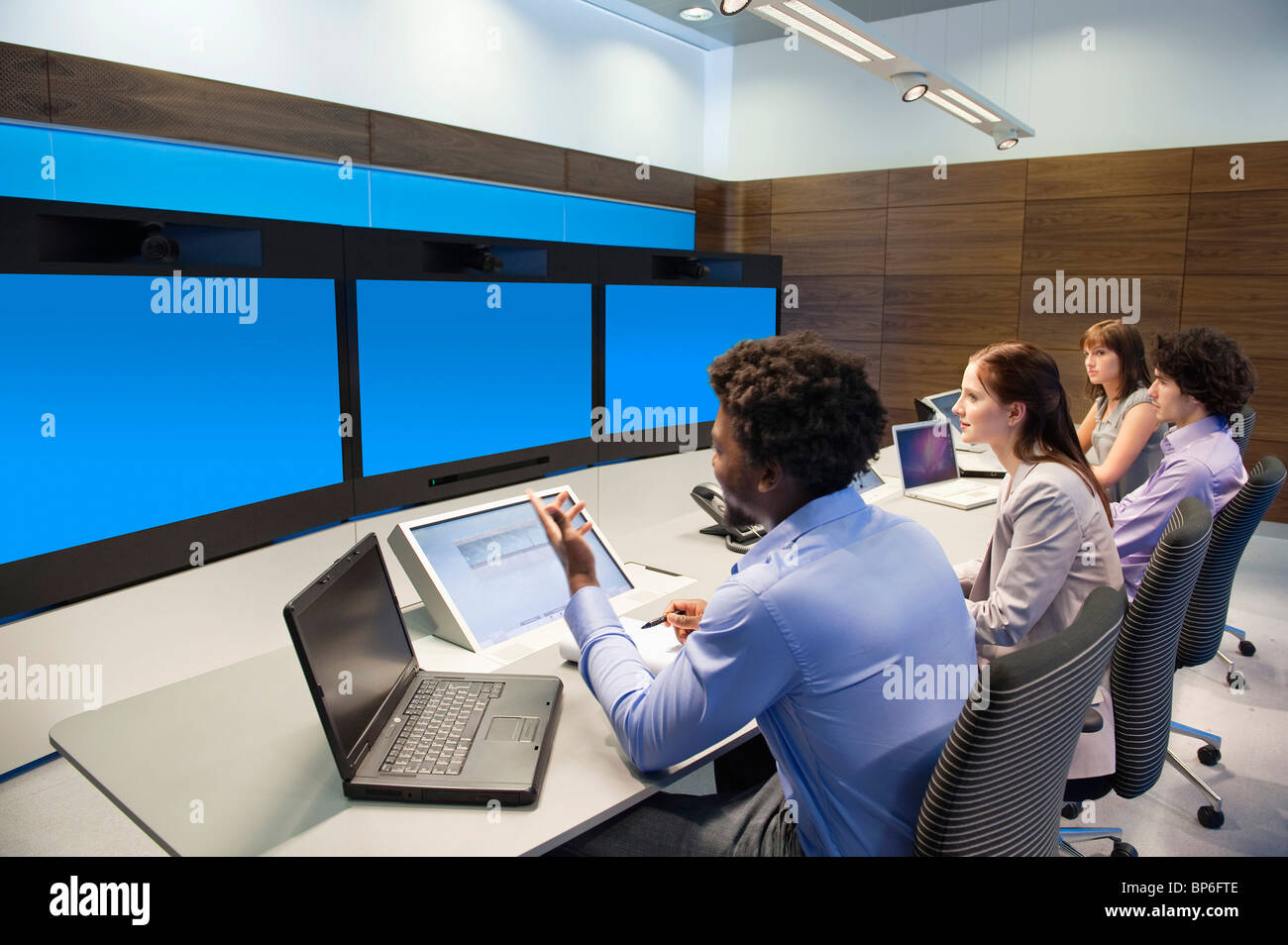 Business executives working in a control room Stock Photo - Alamy