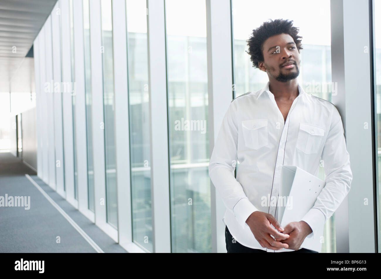 Businessman holding a folder and thinking Stock Photo - Alamy
