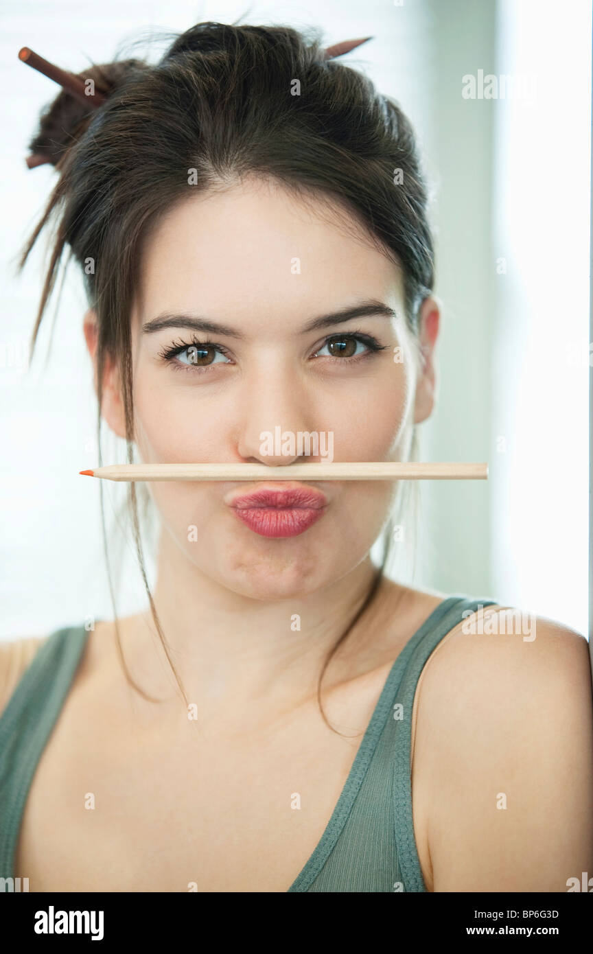 Woman balancing a pencil on lip Stock Photo - Alamy