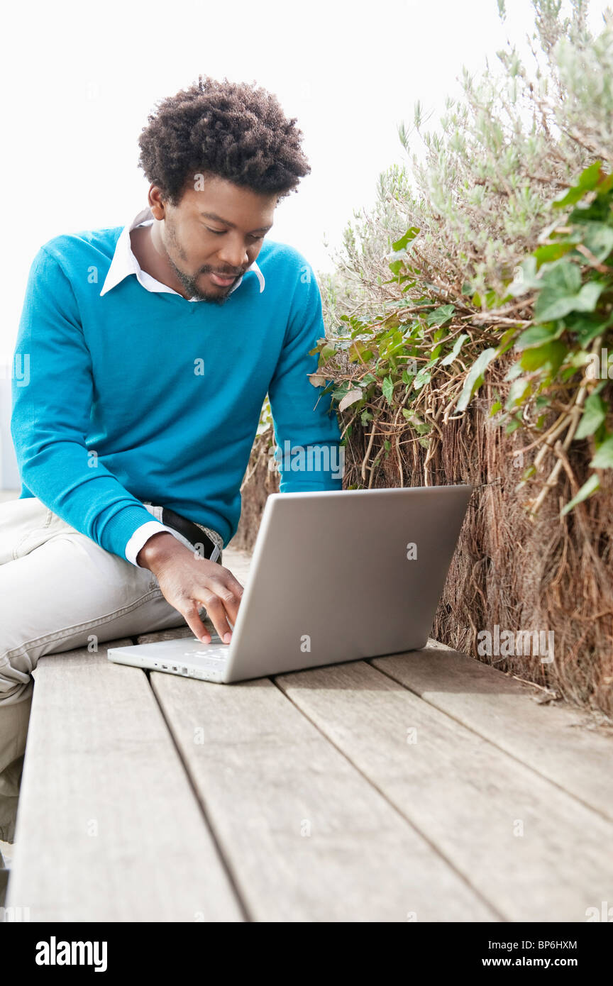 Man using a laptop on a boardwalk Stock Photo - Alamy