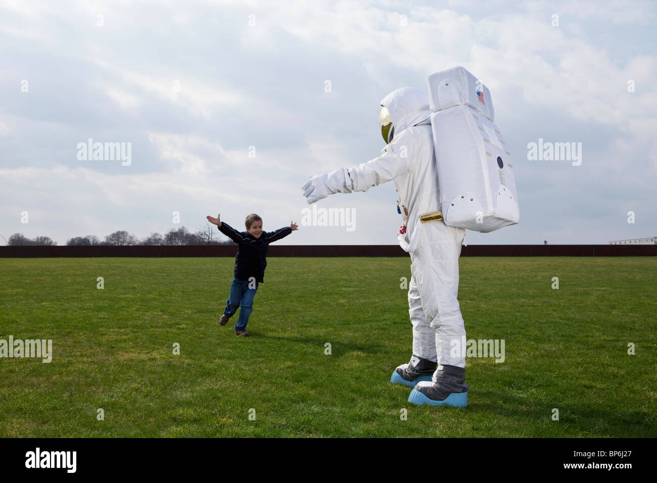 A boy running to meet his astronaut father with his arms outstretched ...