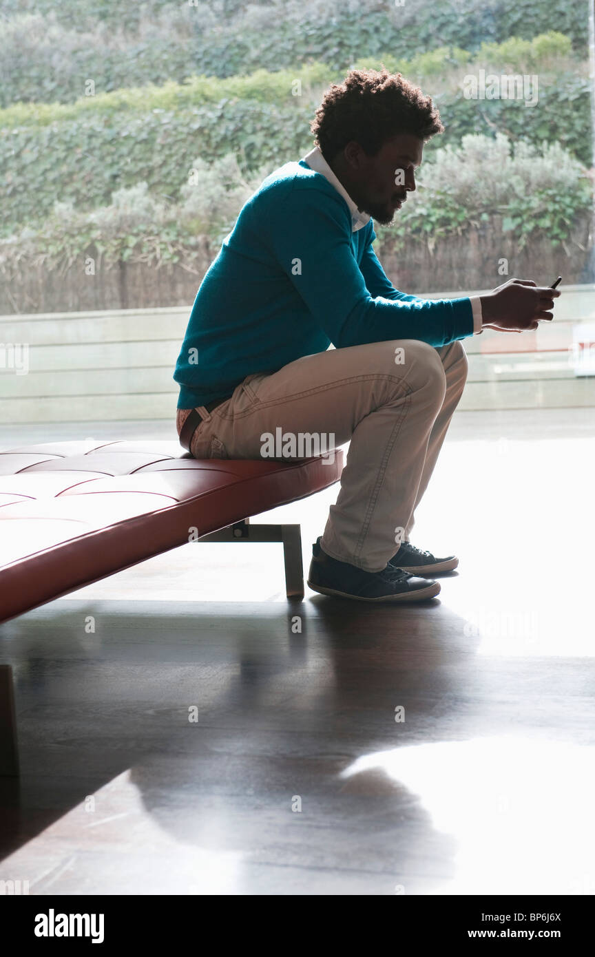 African man phone sitting hi-res stock photography and images - Alamy