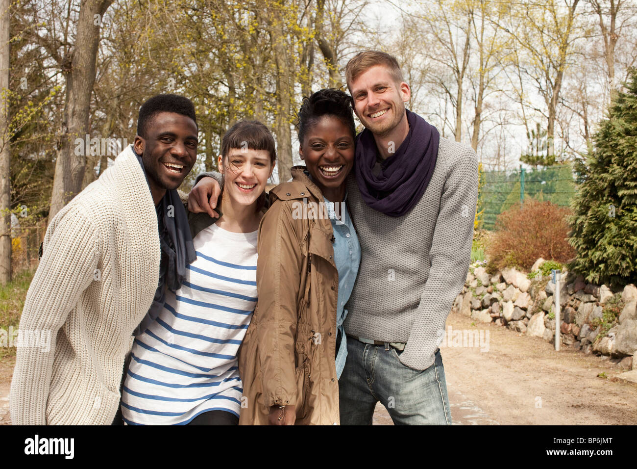 Four friends with their arms around each other Stock Photo - Alamy