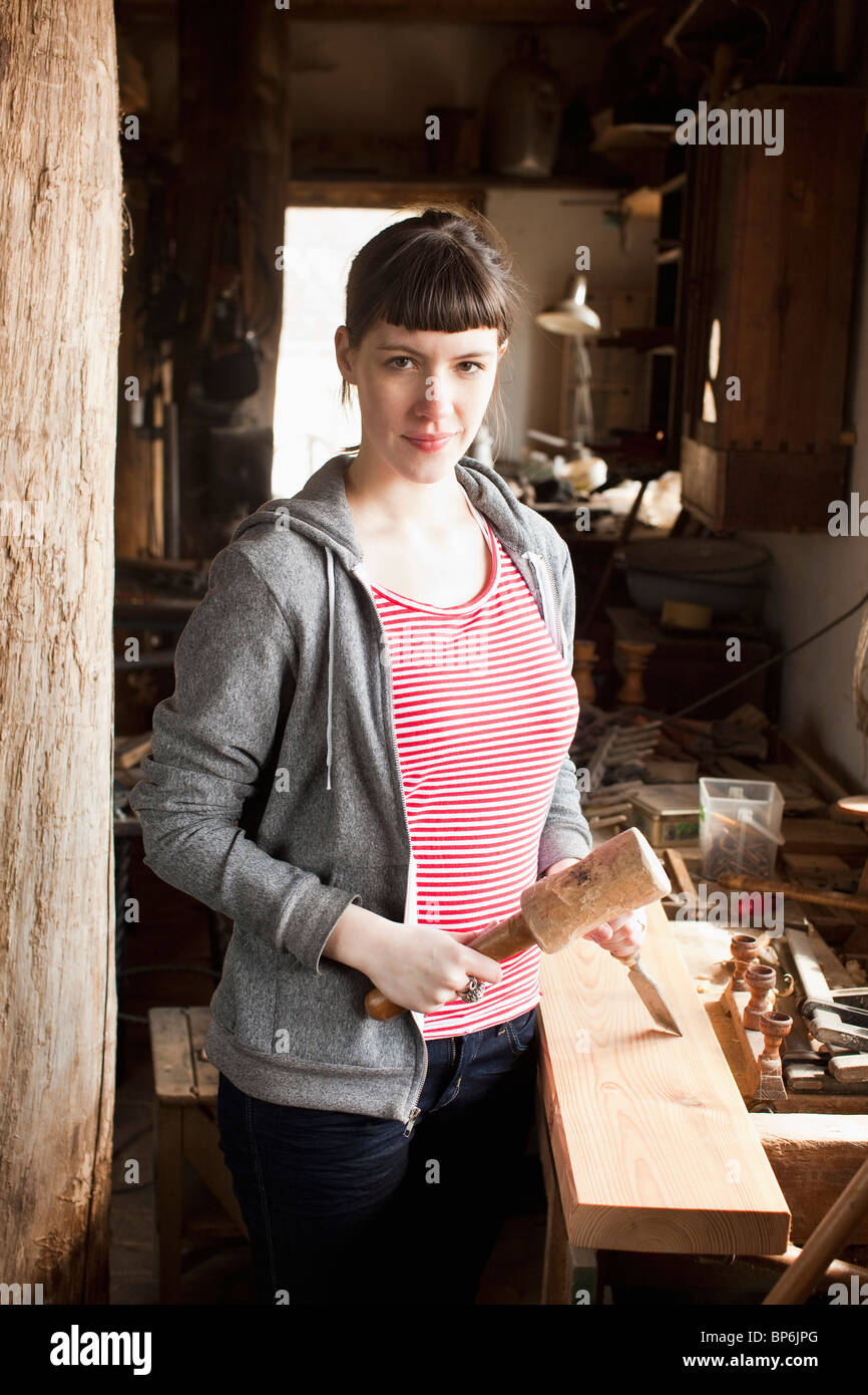 A woman in a workshop holding a chisel and mallet Stock Photo - Alamy