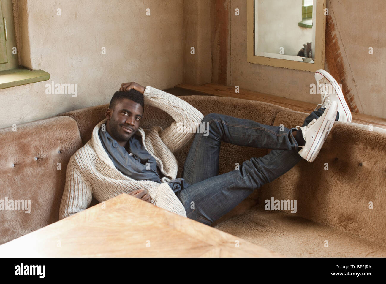 A stylish man reclining in a booth Stock Photo - Alamy