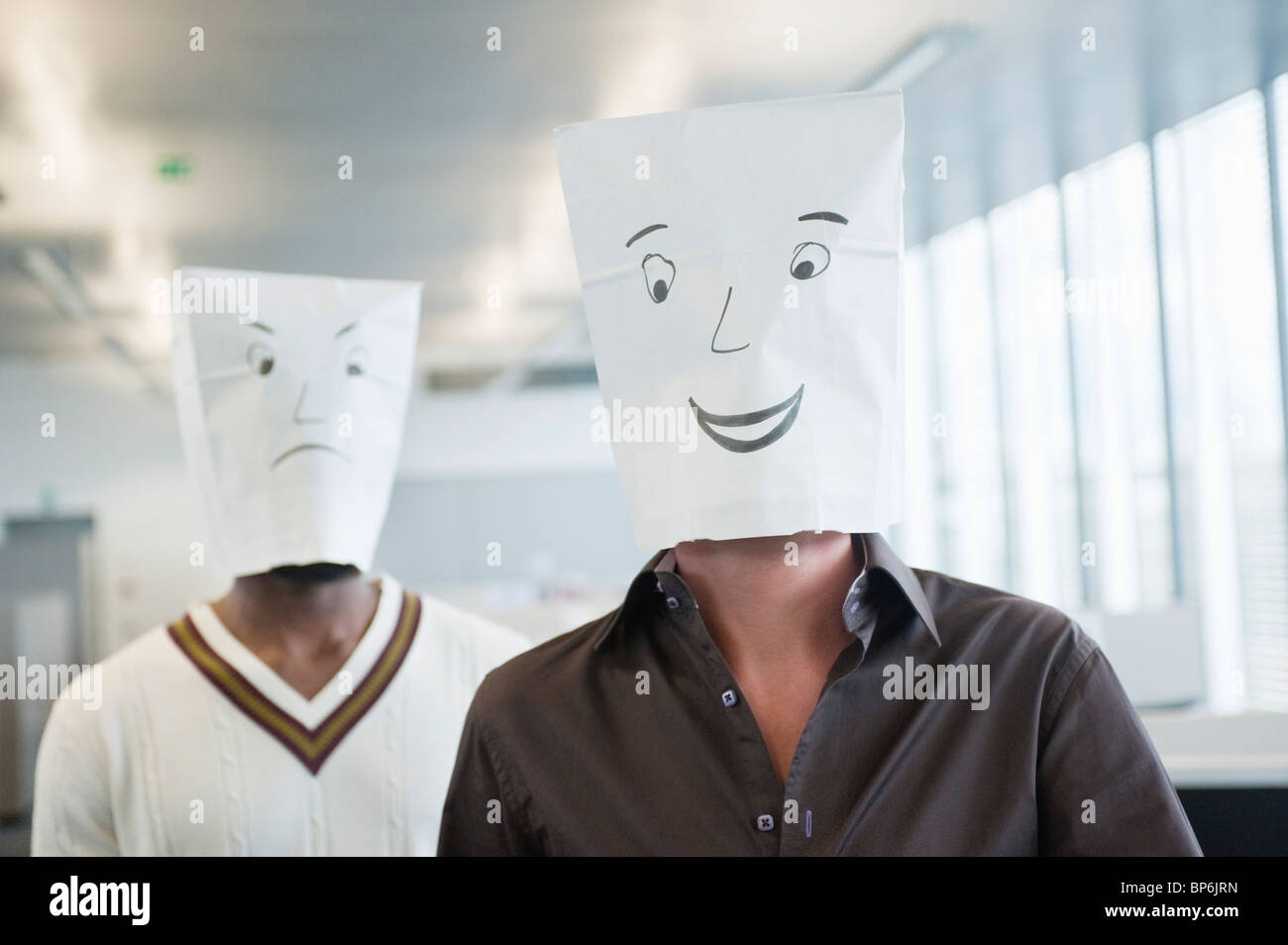 Two businessmen wearing paper bags of happy and sad faces Stock Photo ...