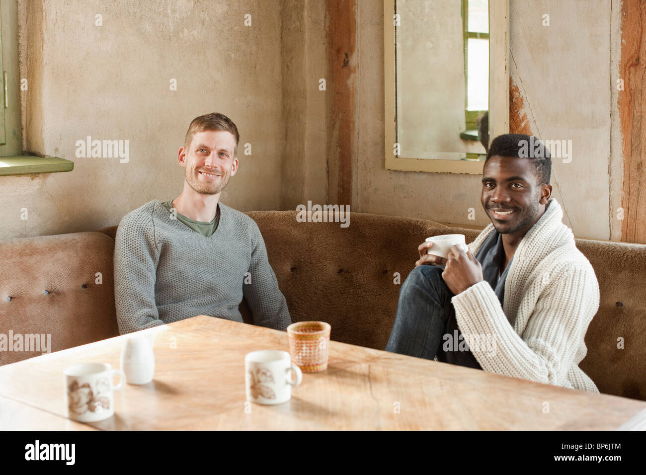 Two friends sitting at table Stock Photo - Alamy