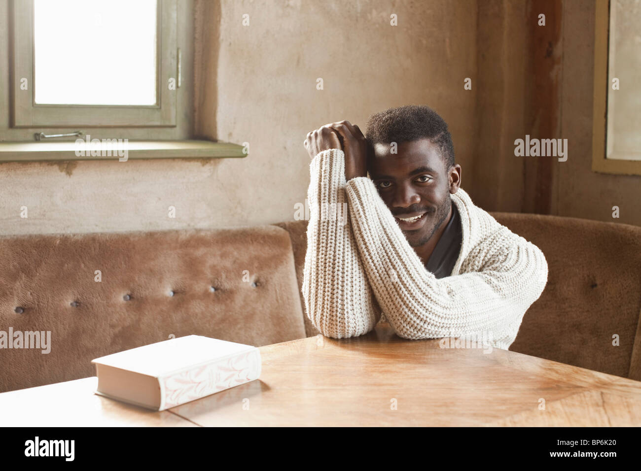 A young man sitting at a table Stock Photo - Alamy
