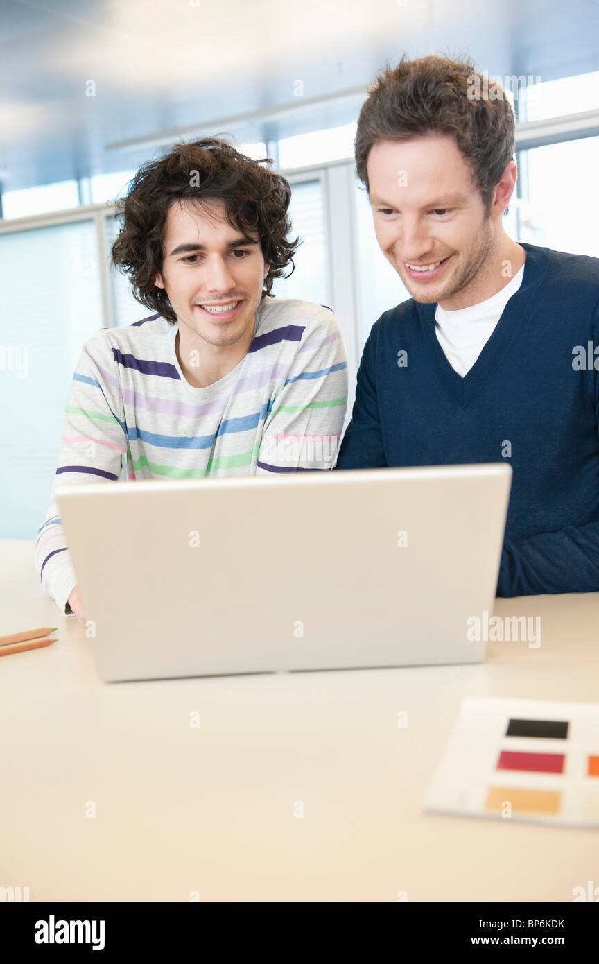 Businessmen using a laptop in an office Stock Photo - Alamy