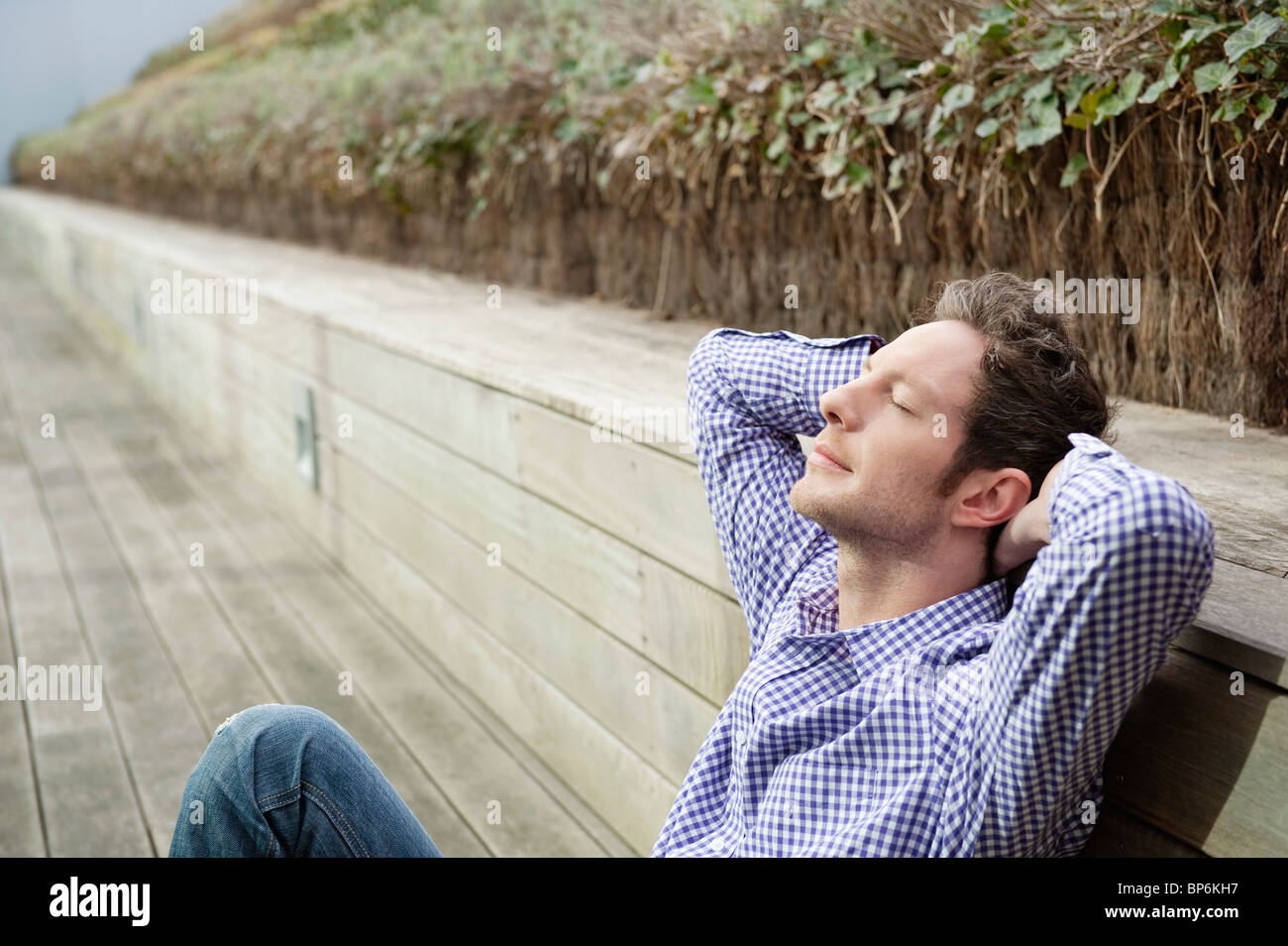 Man resting on a boardwalk Stock Photo - Alamy