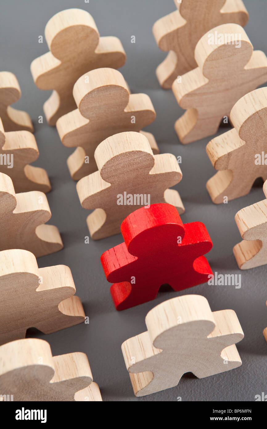 A red wooden stick figure with a group of unpainted wooden stick ...