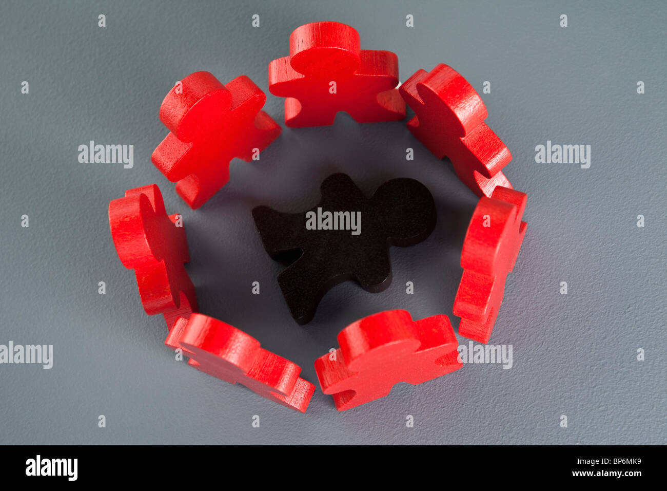 A brown wooden stick figure surrounded by a circle of red wooden stick ...