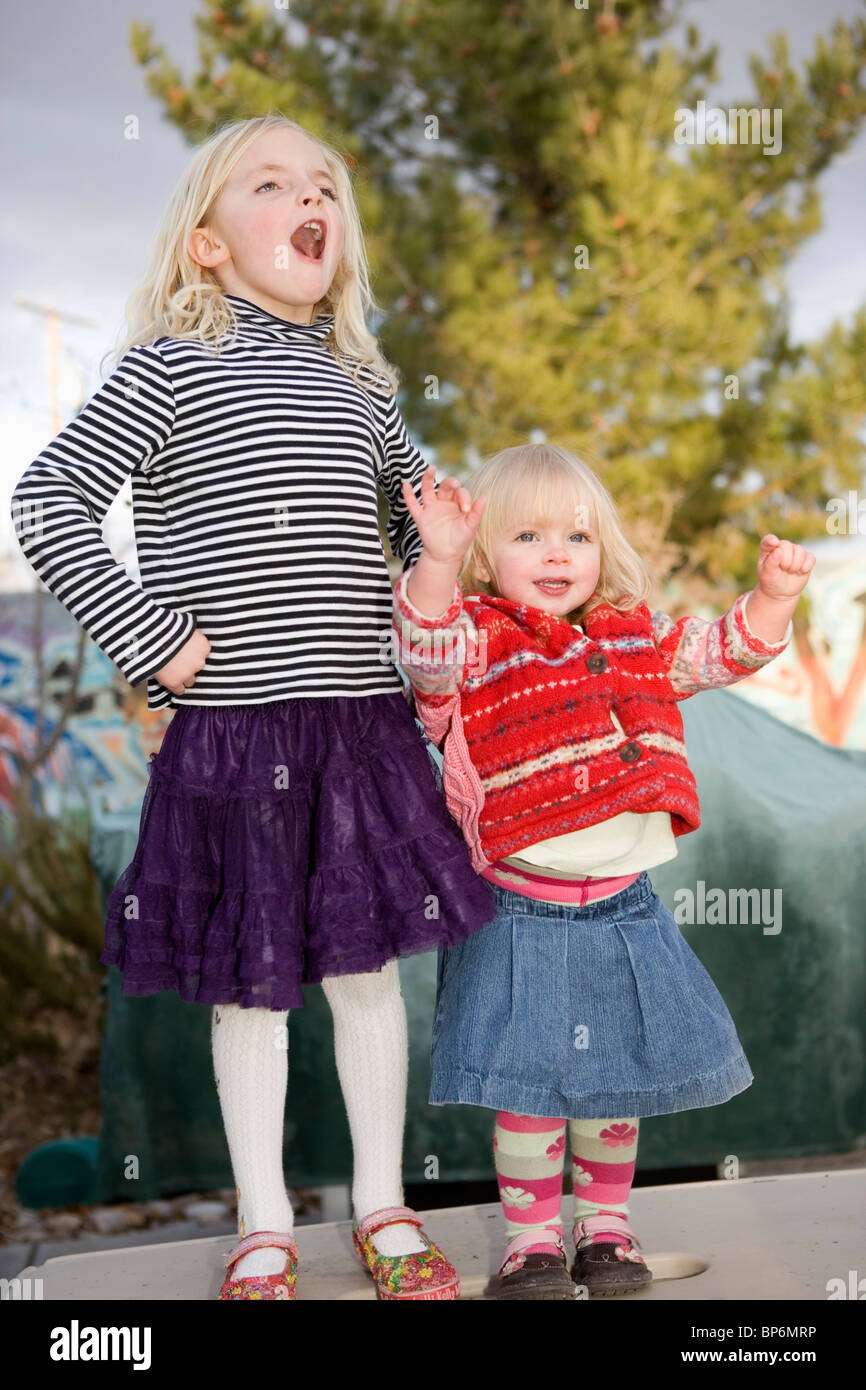 Two girls standing side by side Stock Photo - Alamy