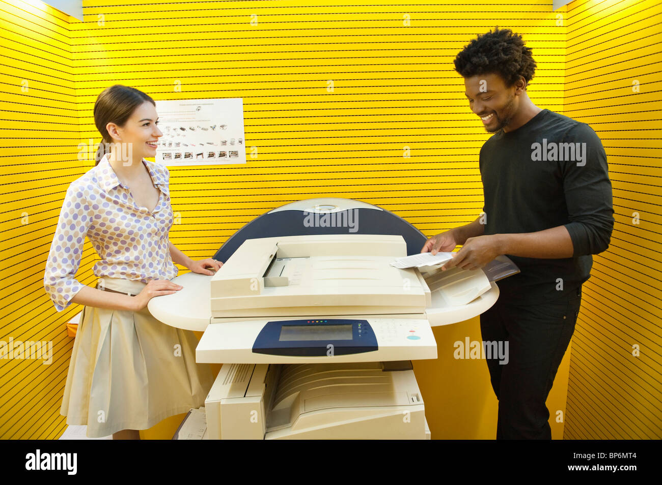 Two women standing at photocopier hi-res stock photography and images ...