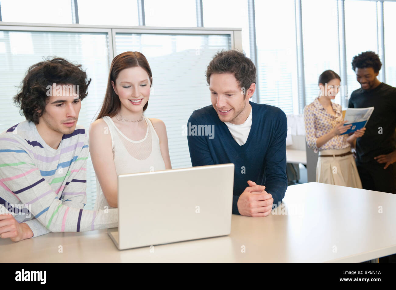 Business executives using a laptop in an office Stock Photo - Alamy