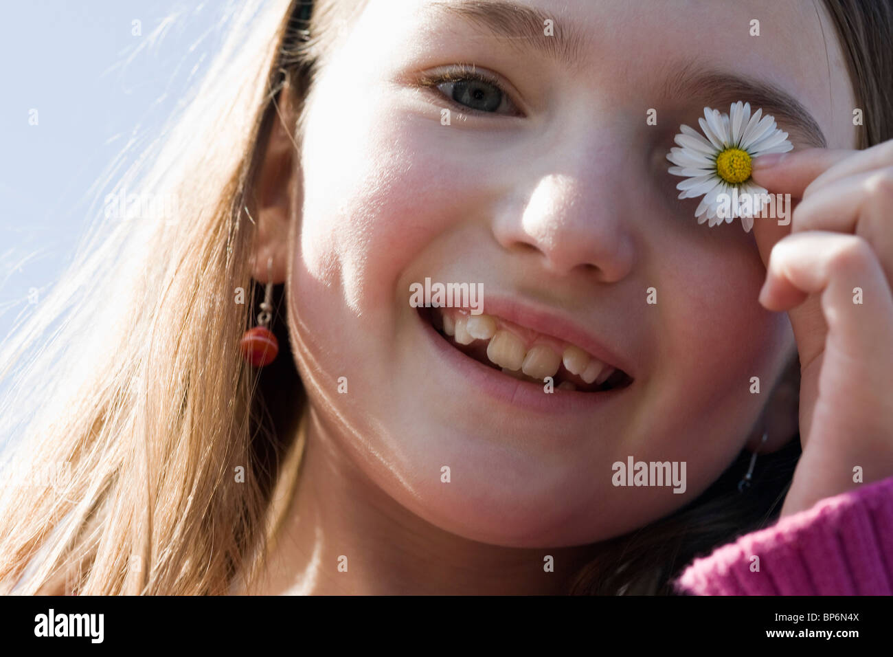 Close-up of a girl holding a flower over her eye Stock Photo - Alamy