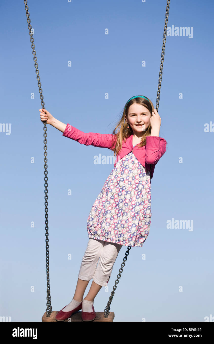 A girl standing on a swing Stock Photo - Alamy