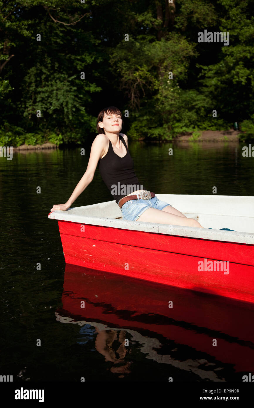 A young woman sunbathing in a rowboat Stock Photo - Alamy