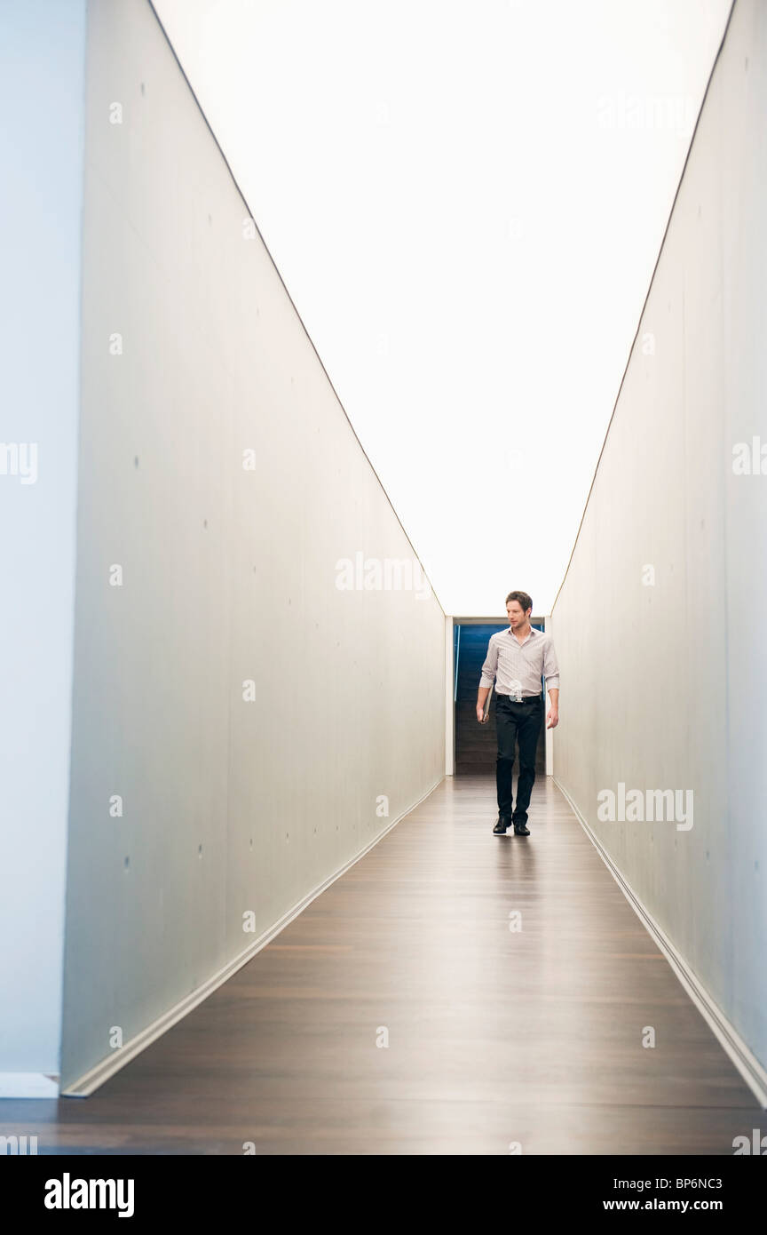 Businessman walking in the corridor of an office Stock Photo - Alamy