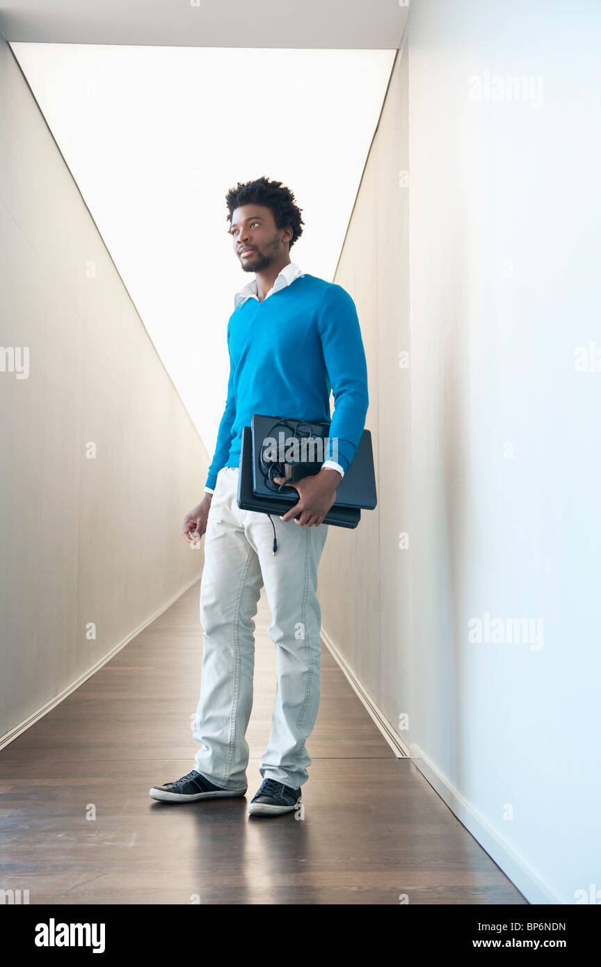 Businessman carrying two laptops in the corridor of an office Stock ...