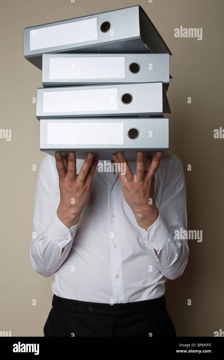 A man standing behind a stack folders Stock Photo - Alamy