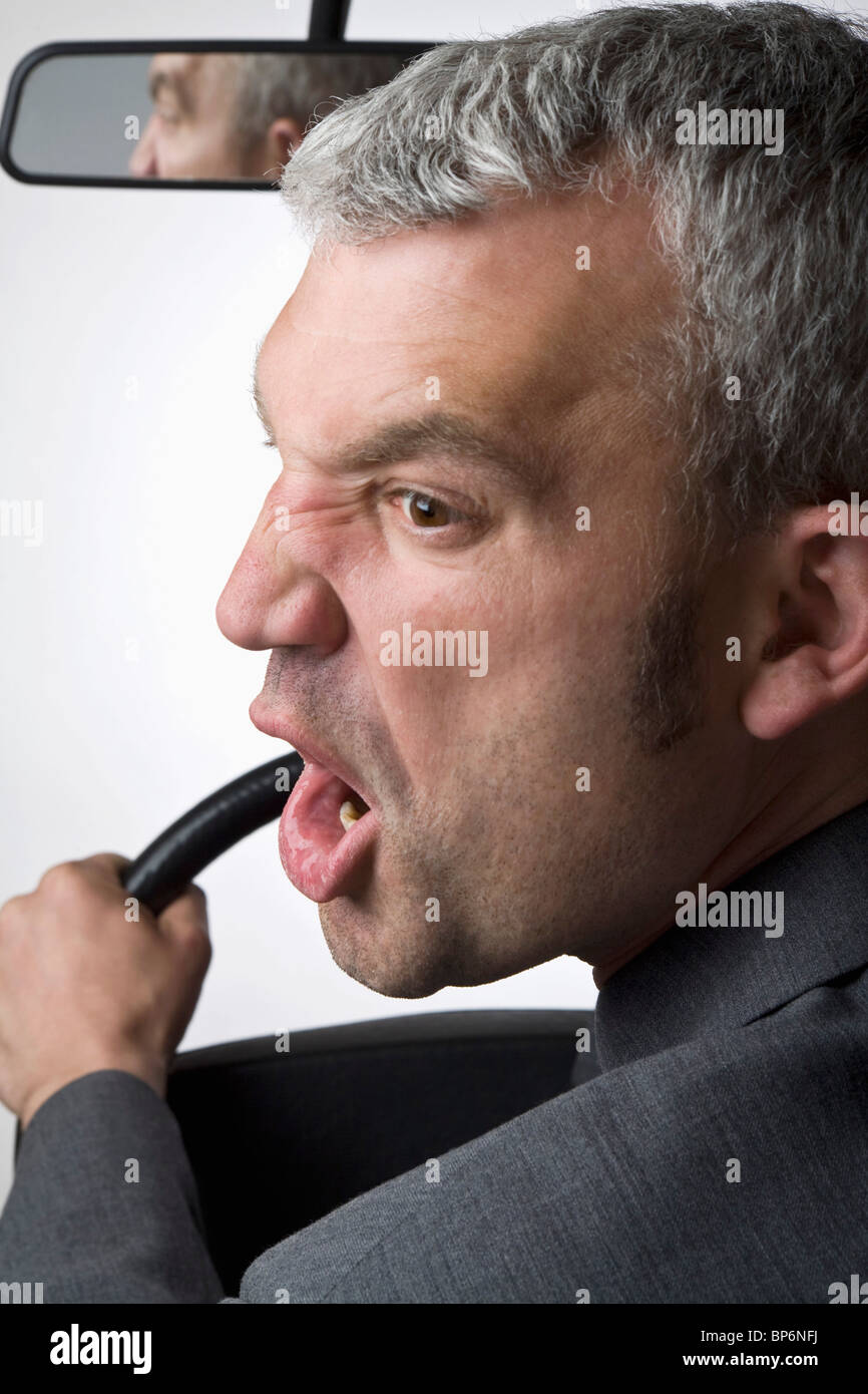 A man yelling over his shoulder whilst driving a car Stock Photo - Alamy