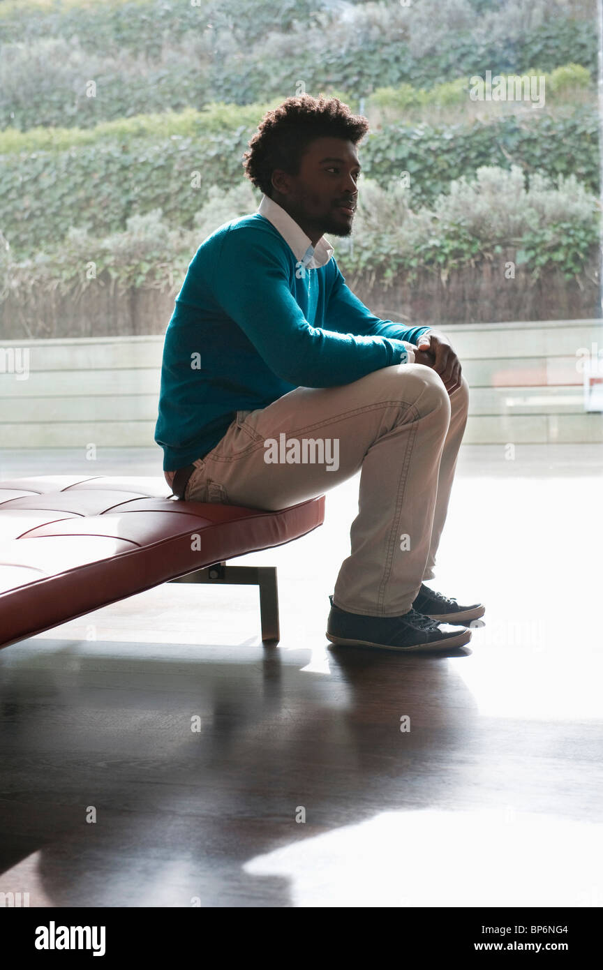 Man sitting on a couch and thinking Stock Photo - Alamy