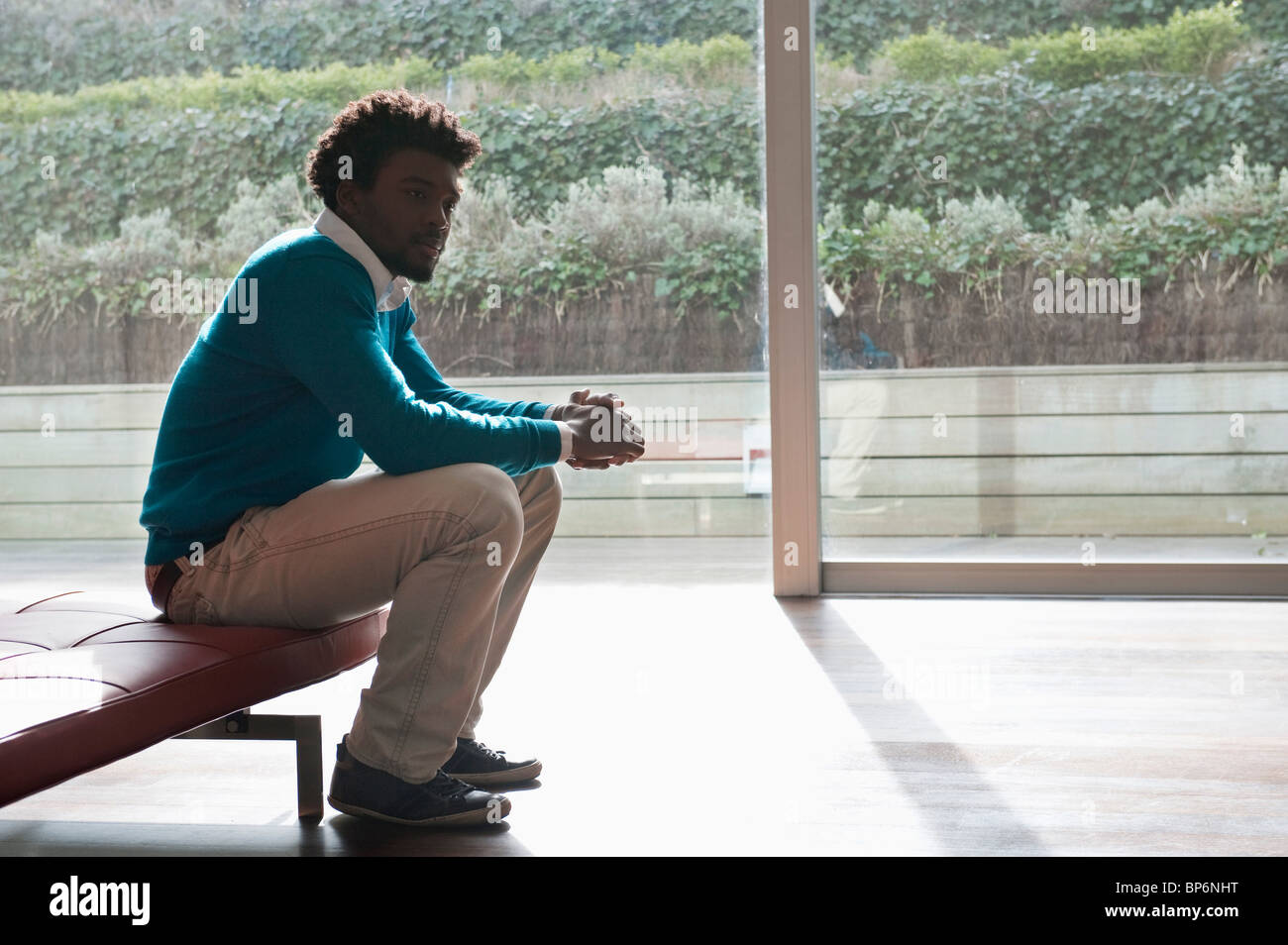 Man sitting on a couch and thinking Stock Photo - Alamy
