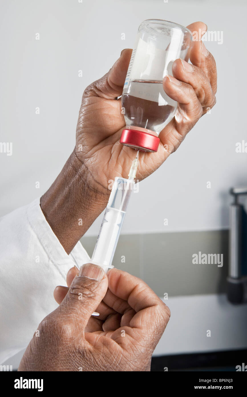 A doctor filling a syringe, focus on hands Stock Photo - Alamy